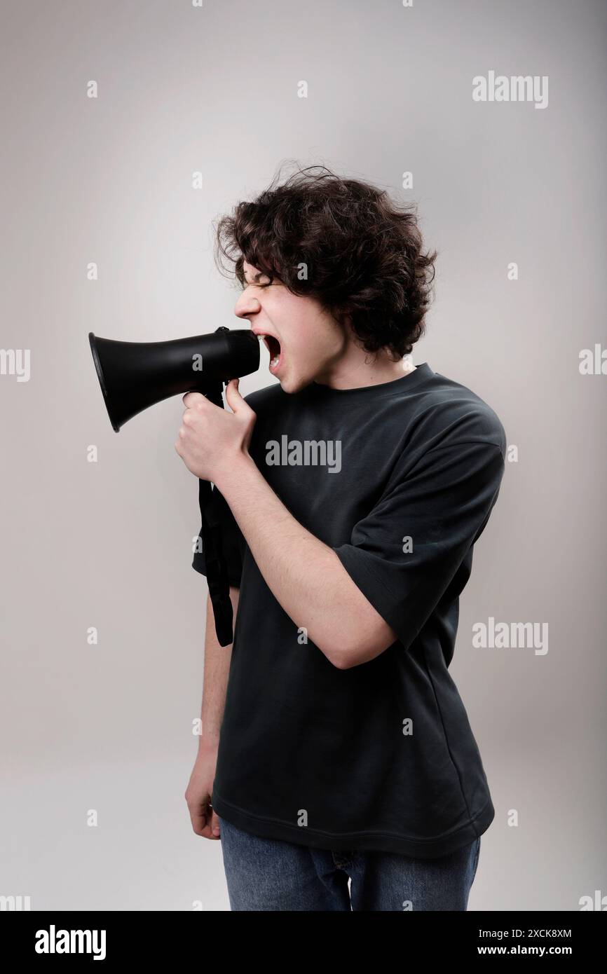 student with megaphone shouting on light background Stock Photo - Alamy