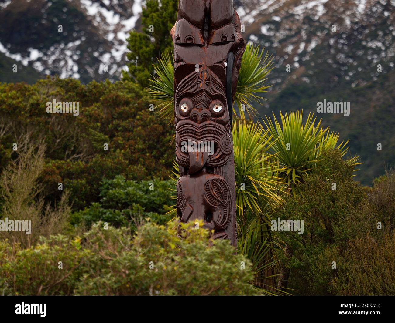 Detailed closeup of typical traditional Pou Whenua wooden pole Whakairo ...