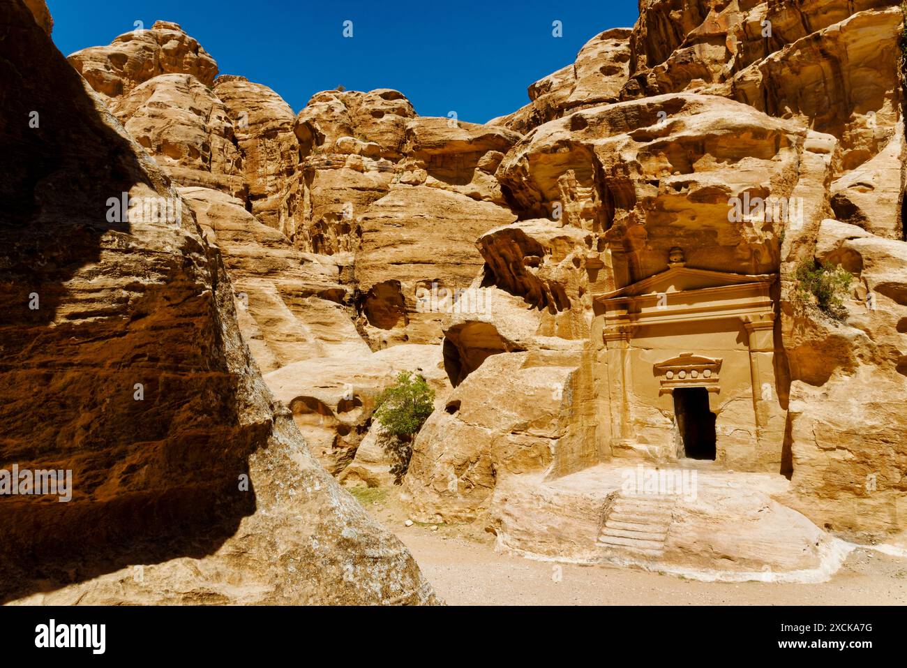 Entrance of ancient building carved in rock wall, Petra, Jordan Stock ...