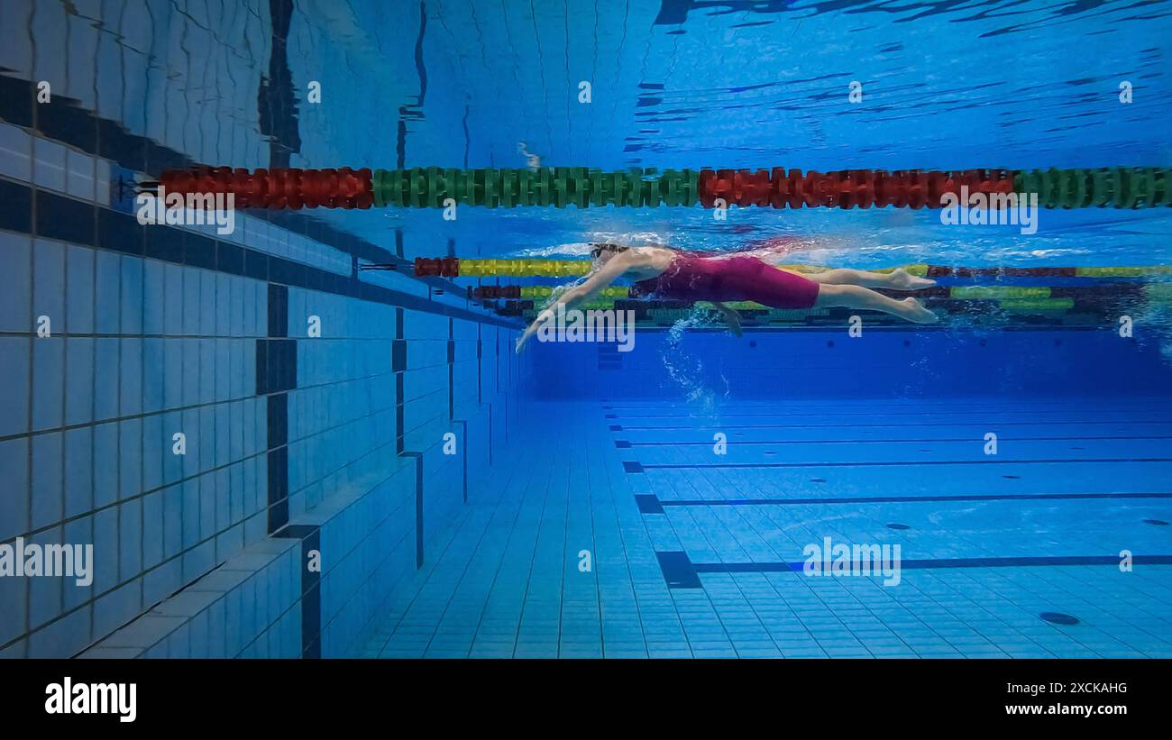 Female swimmer in the water immersion phase, sliding below the water ...