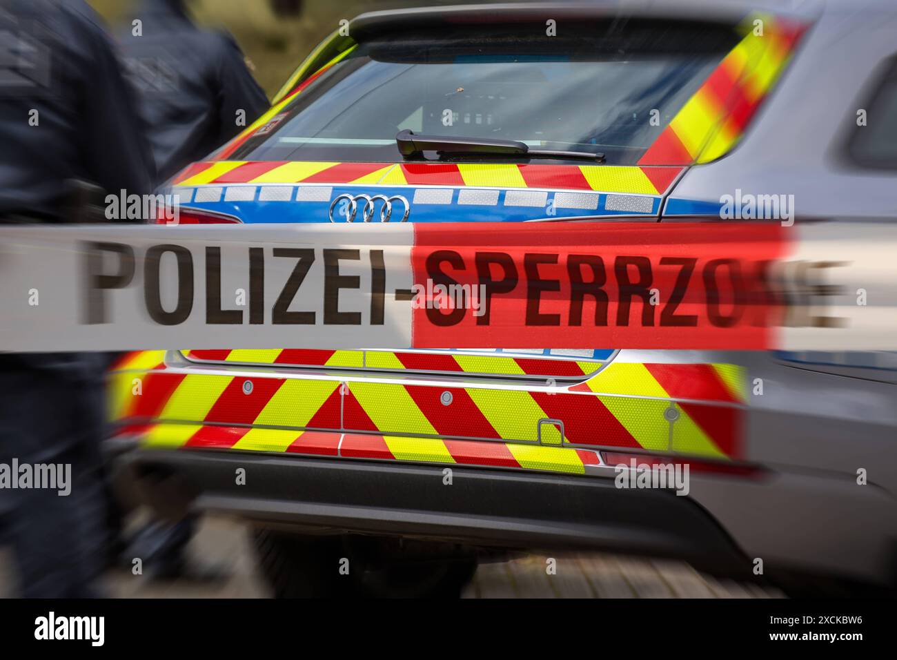 Symbolbild: Polizeiabsperrung mit Polizeifahrzeug im Hintergrund ...