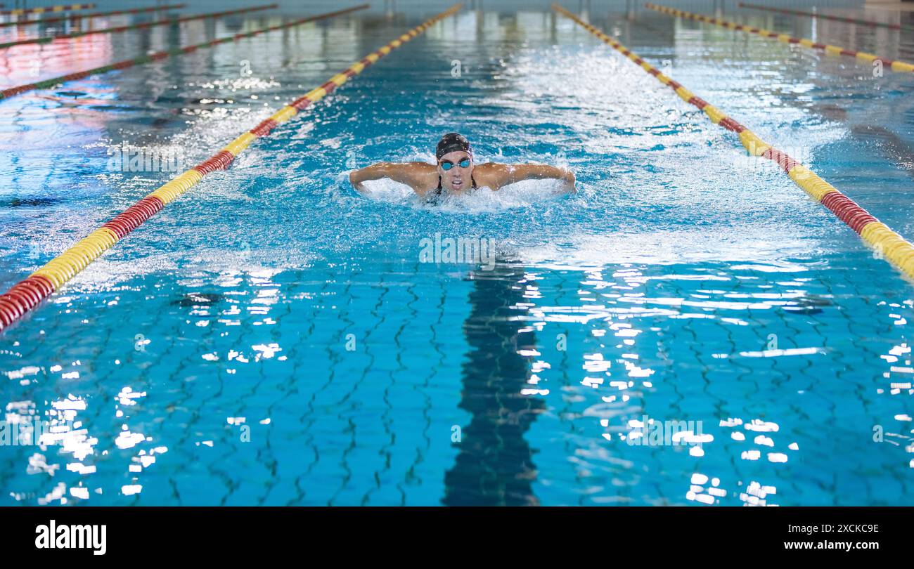 Front view of a female swimmer swimming butterfly style, a stroke ...