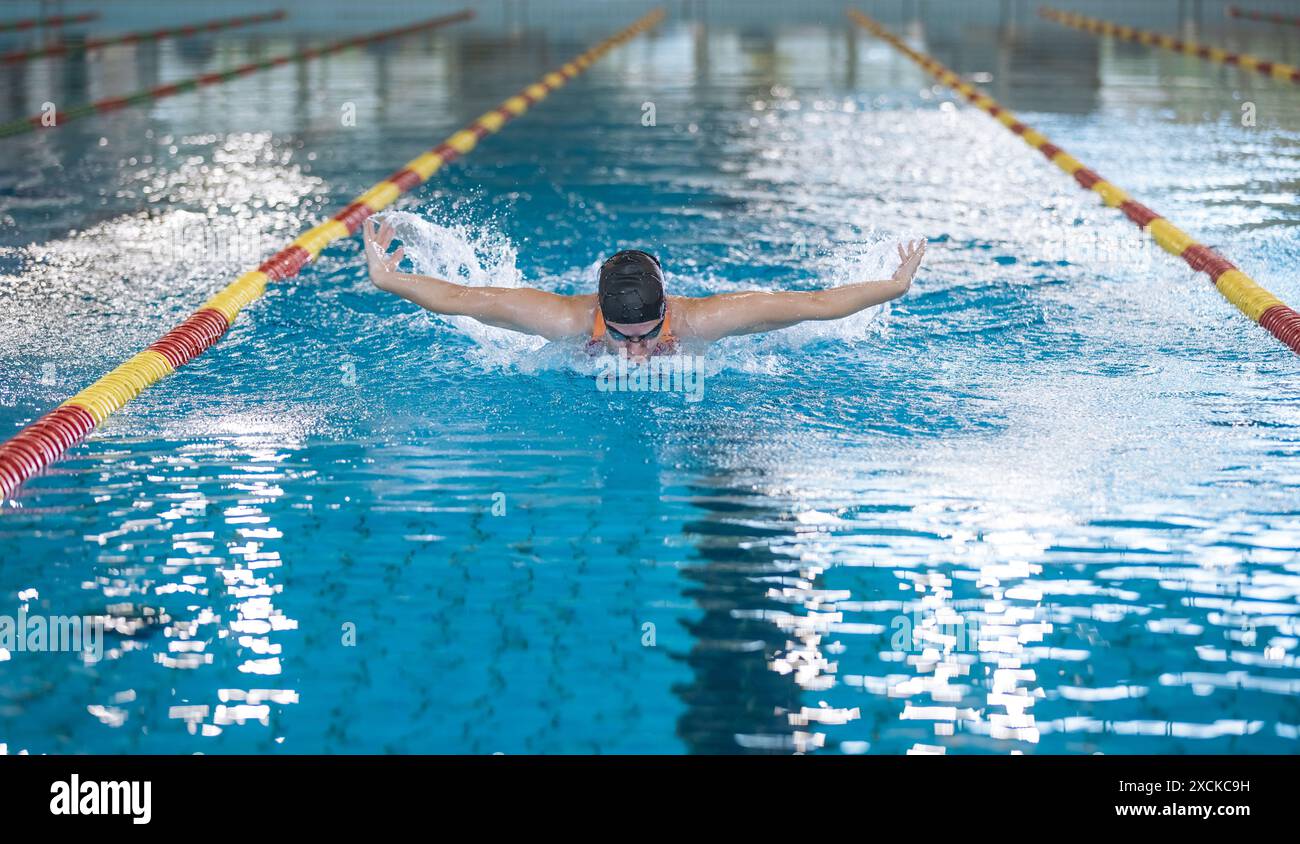 Successful professional female swimmer swimming butterfly stroke in the ...