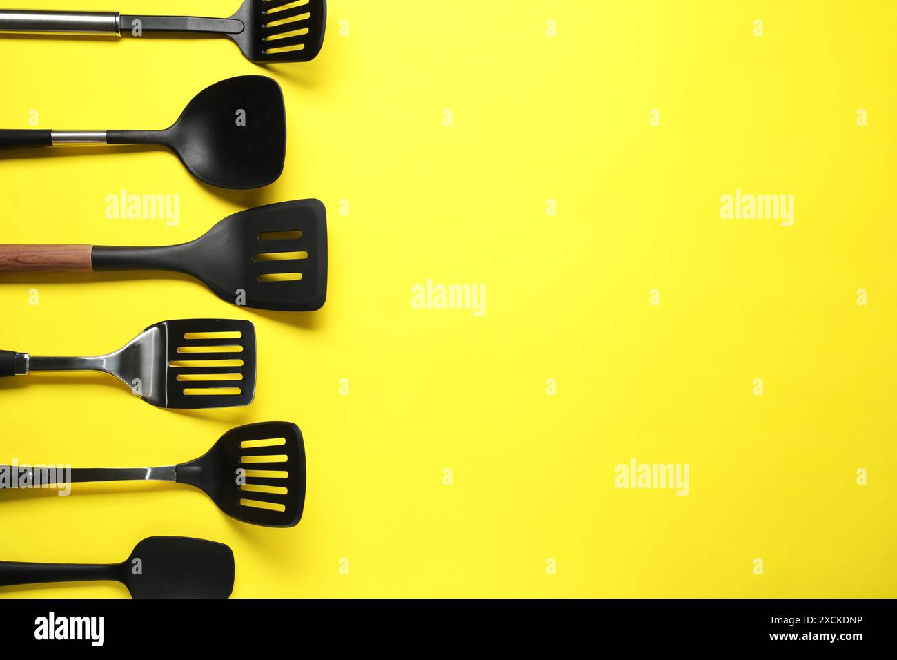 Different spatulas on yellow background, flat lay. Space for text Stock ...