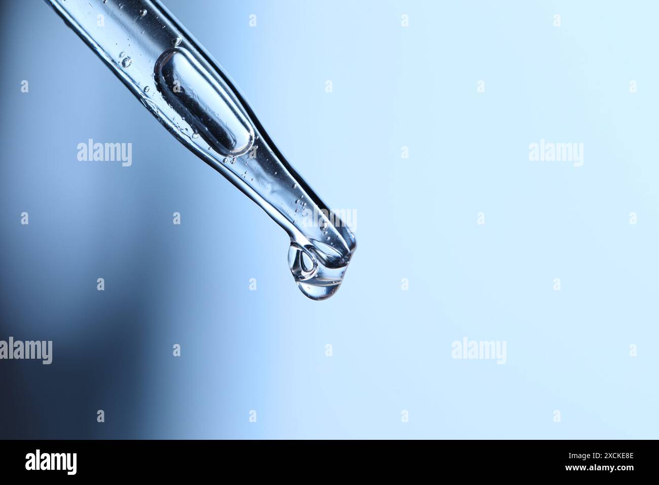 Dripping liquid from pipette on light blue background, closeup Stock ...