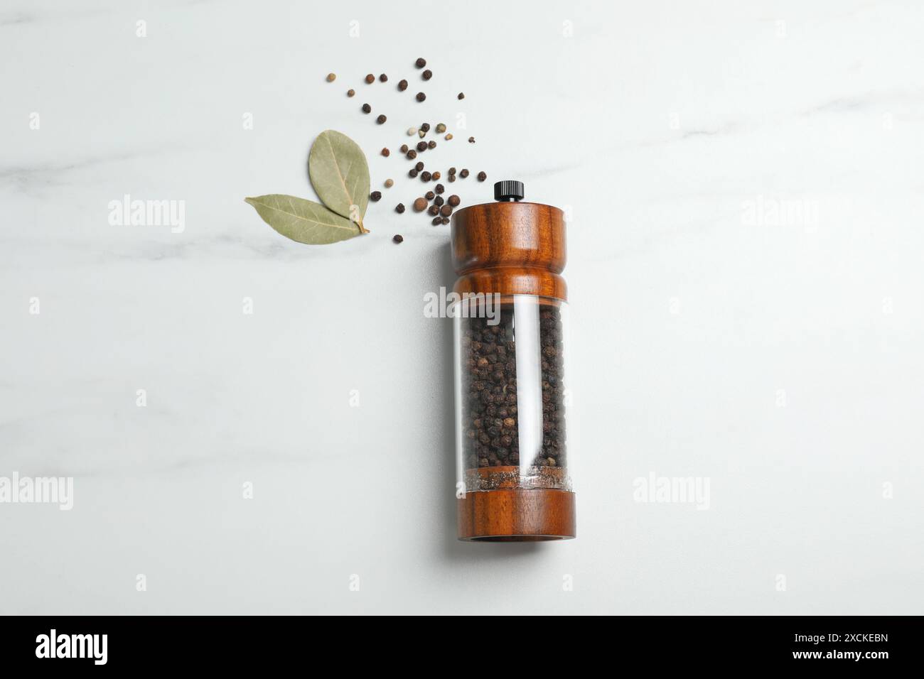 Pepper shaker and bay leaves on white marble table, flat lay Stock ...