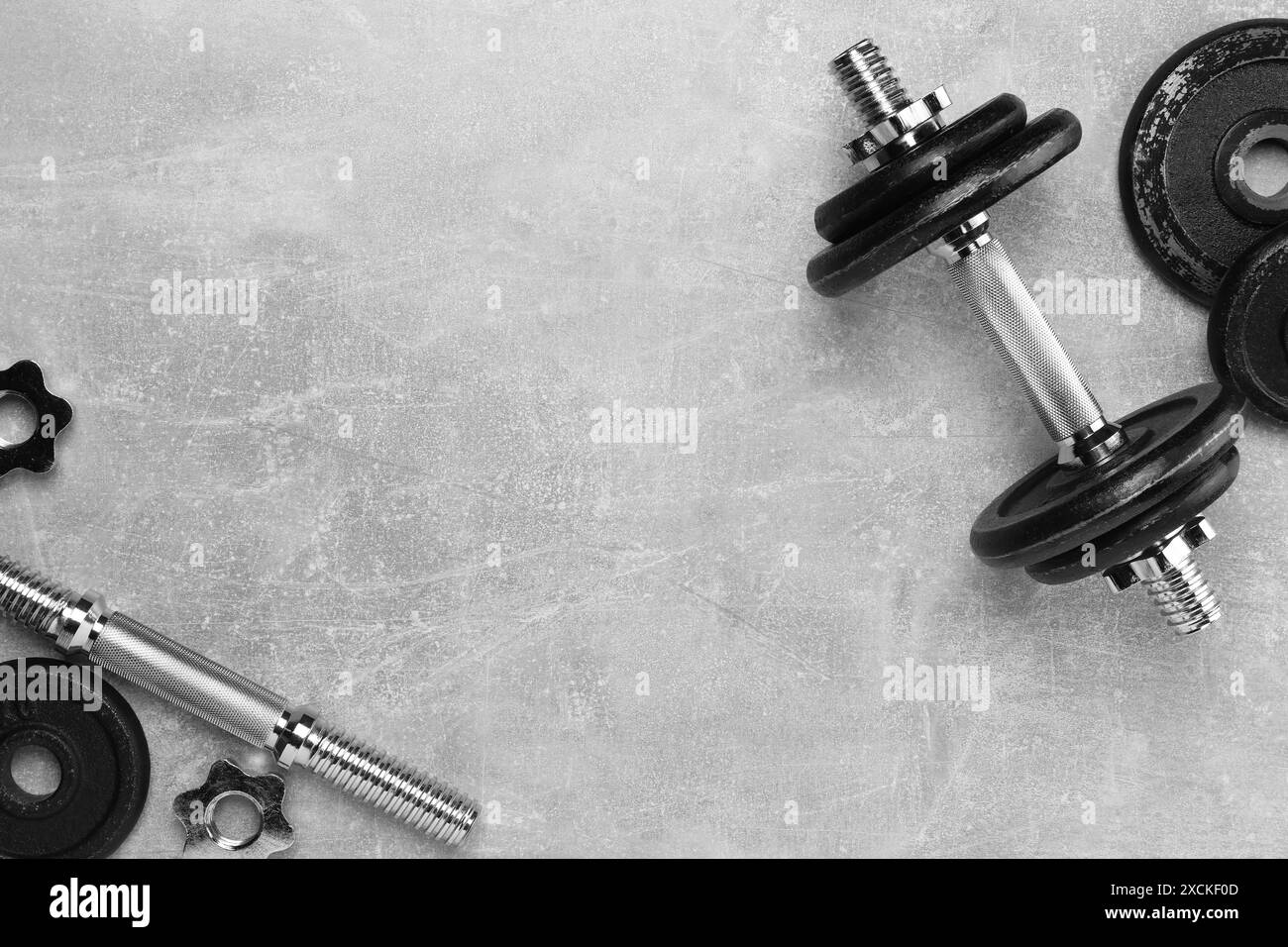 Barbell and parts of one on grey textured background, flat lay. Space ...