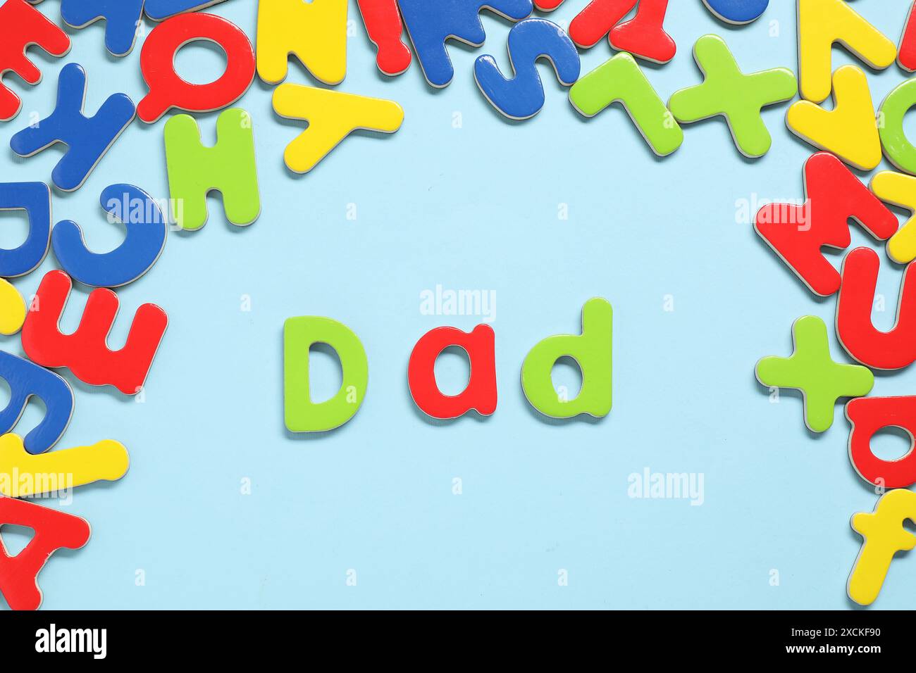Word Dad made of magnetic letters on light blue background, flat lay ...
