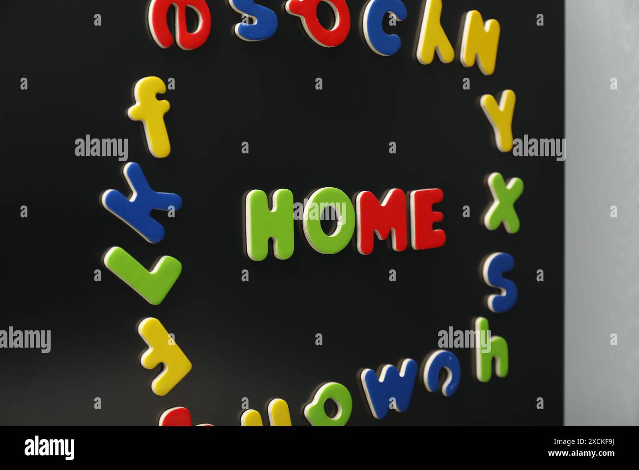Word Home and frame made of many bright magnetic letters on fridge ...
