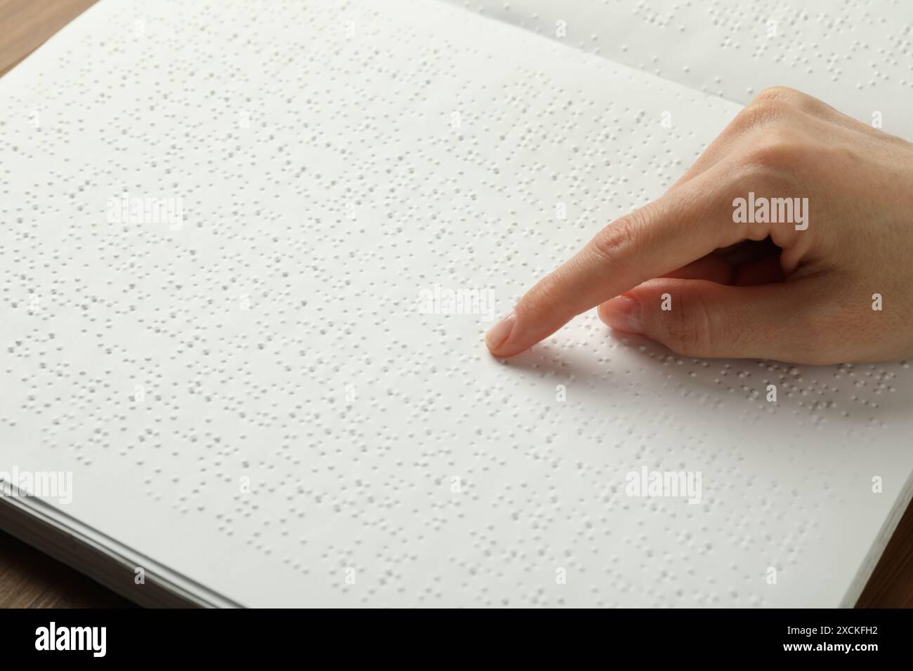 Blind woman reading book written in Braille at table, closeup Stock ...