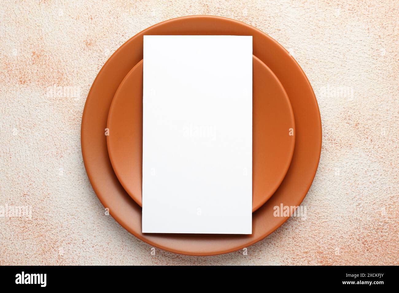 Empty menu and plates on color textured table, top view. Mockup for ...