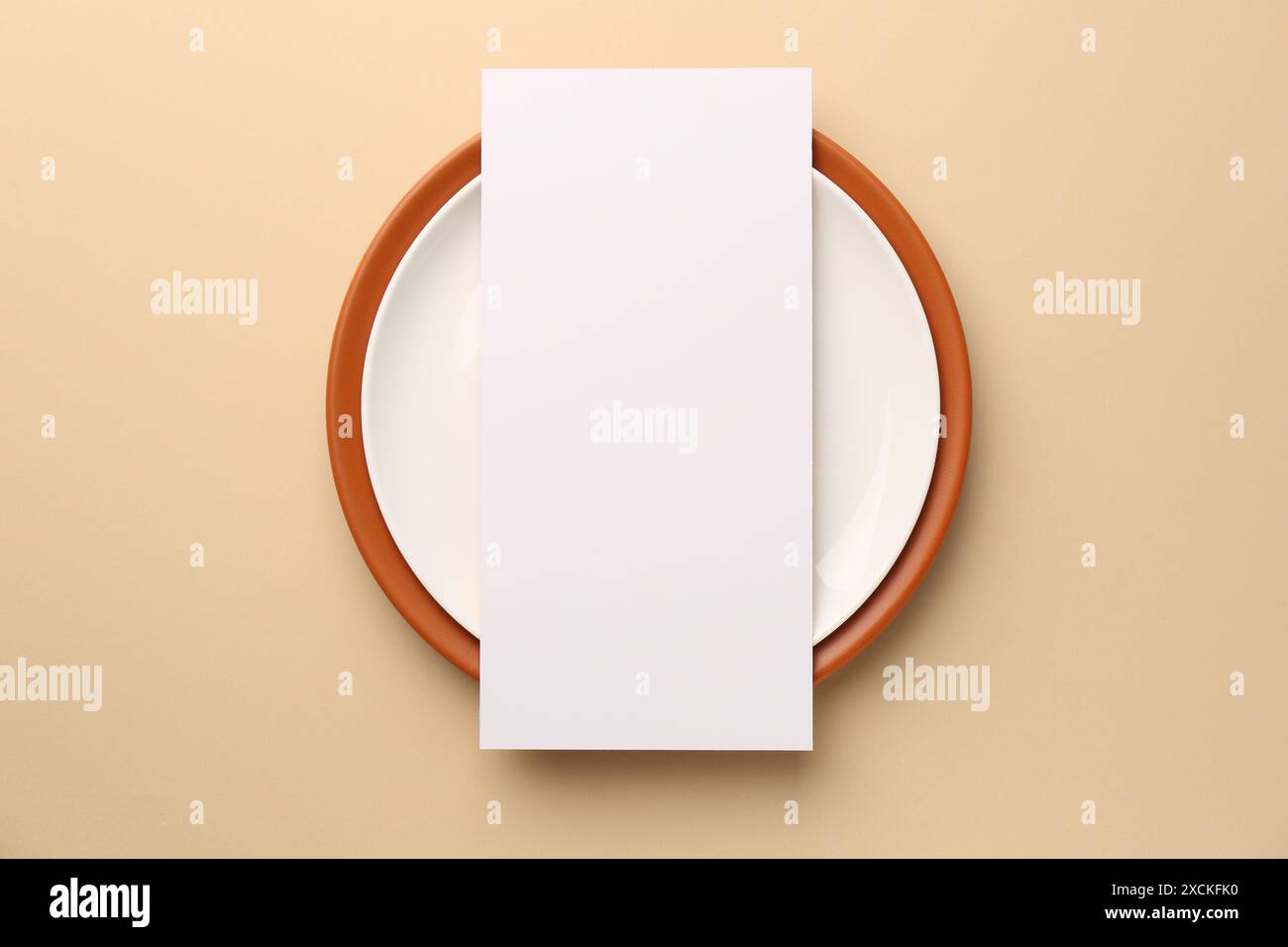Empty menu and plates on beige background, top view. Mockup for design ...