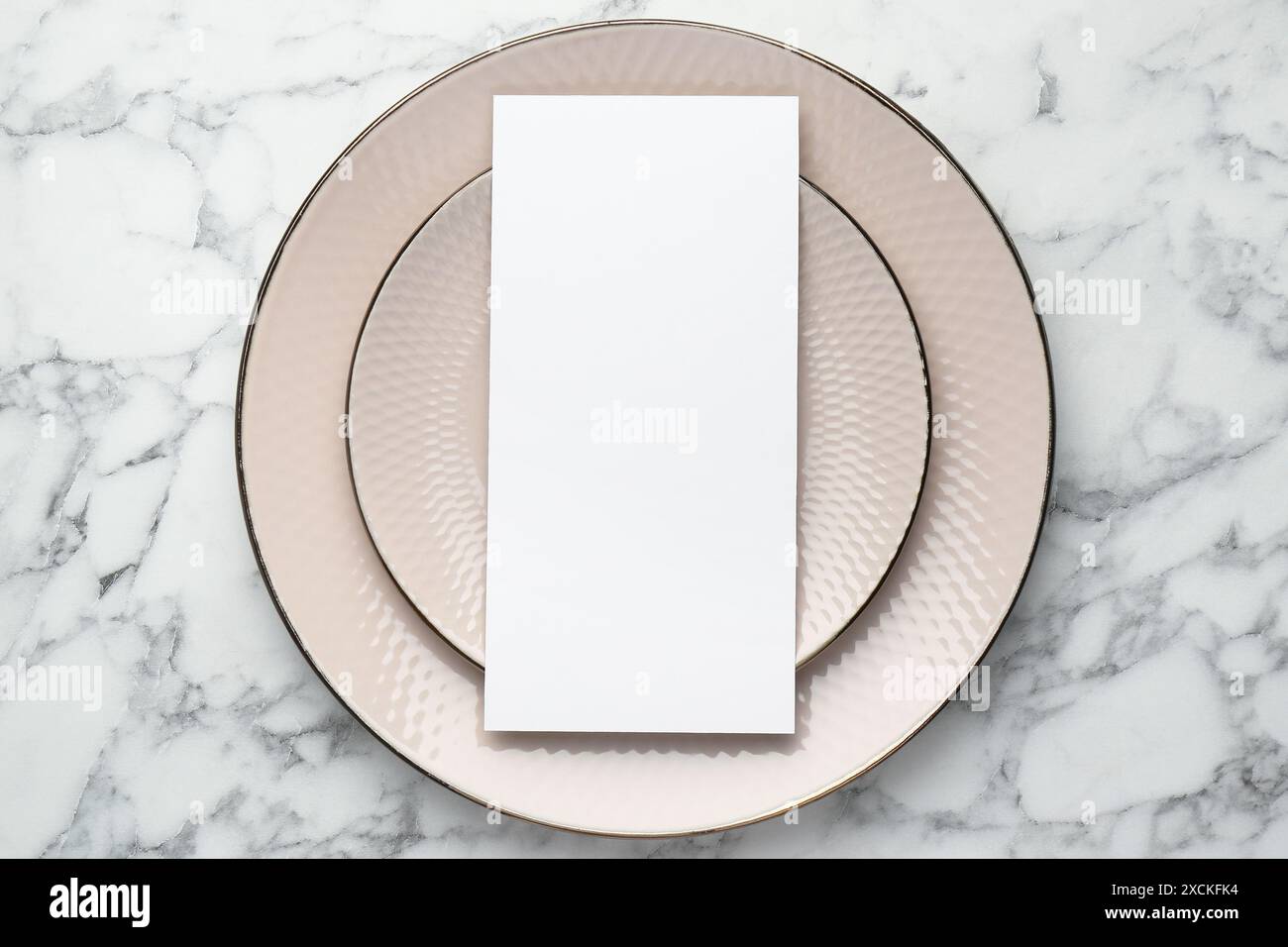 Empty menu and plates on white marble table, top view. Mockup for ...
