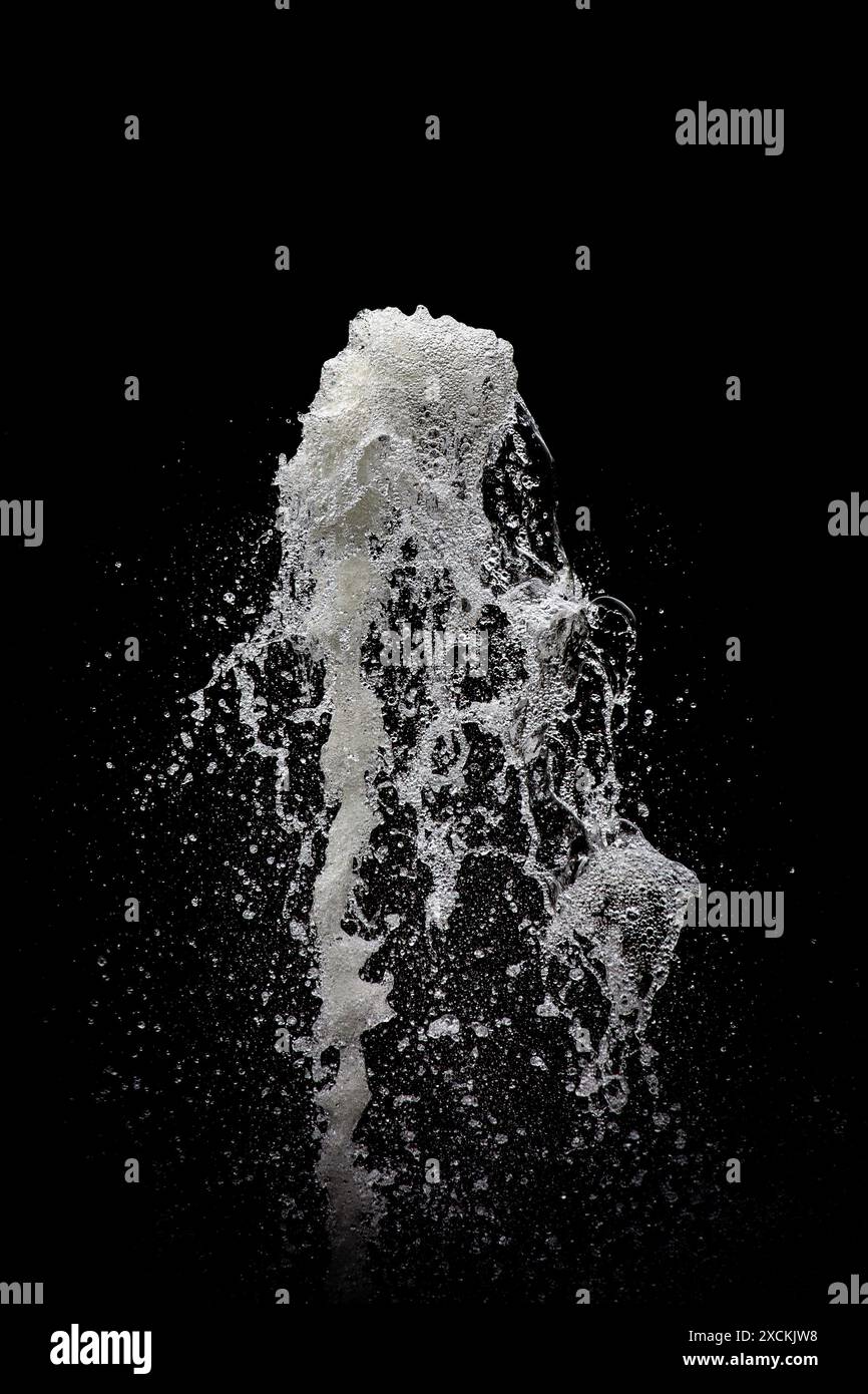 Water exploding into the air with a black background, vertical Stock ...