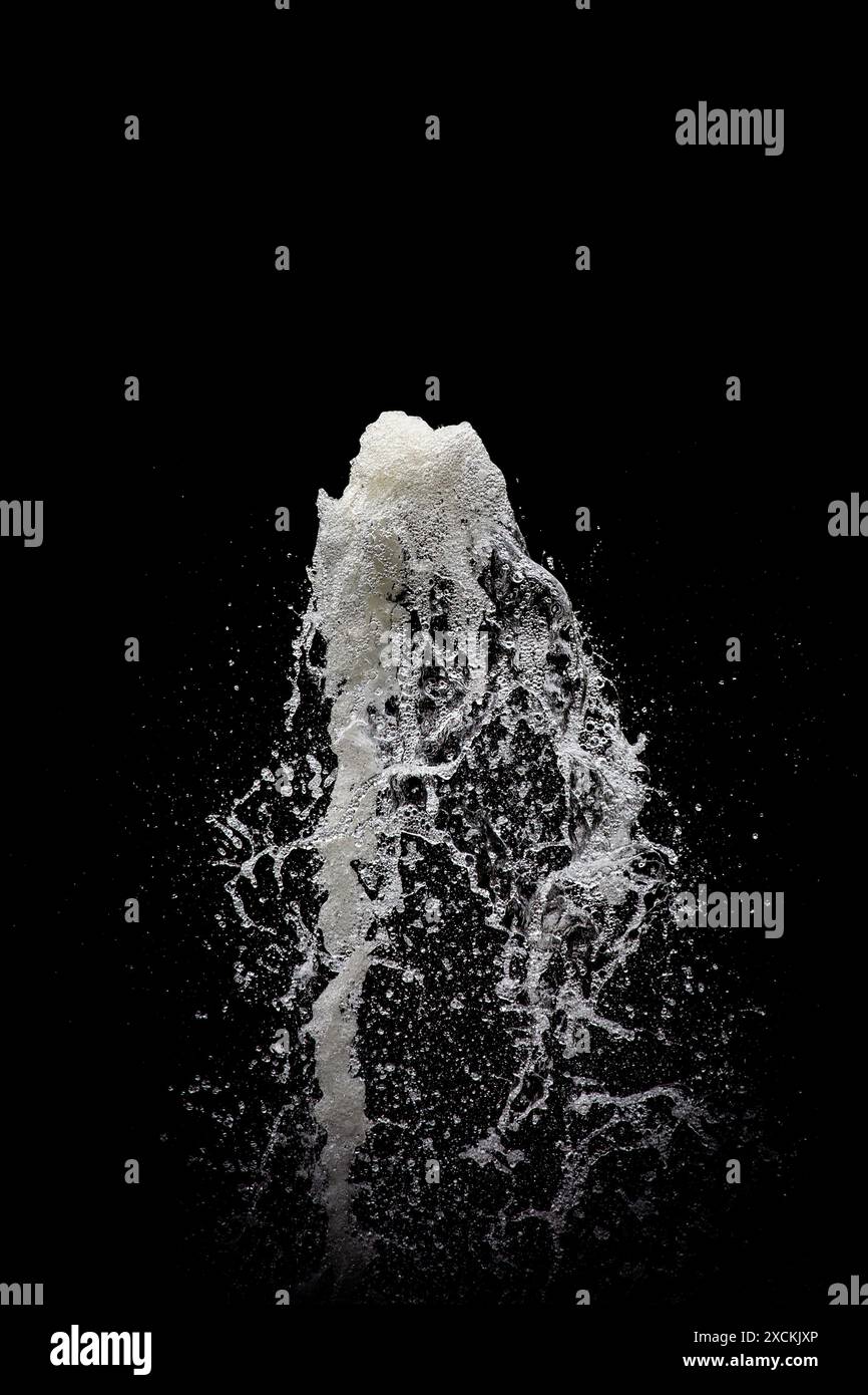Water exploding into the air with a black background, vertical Stock ...