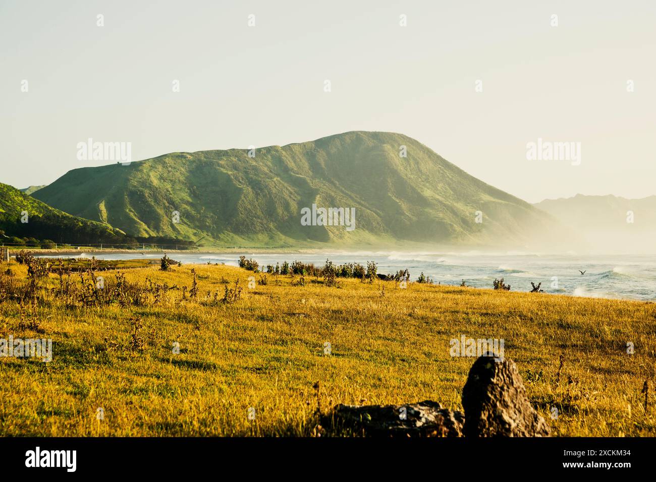 Coast scene bay foreshore and sea with hill Stock Photo - Alamy