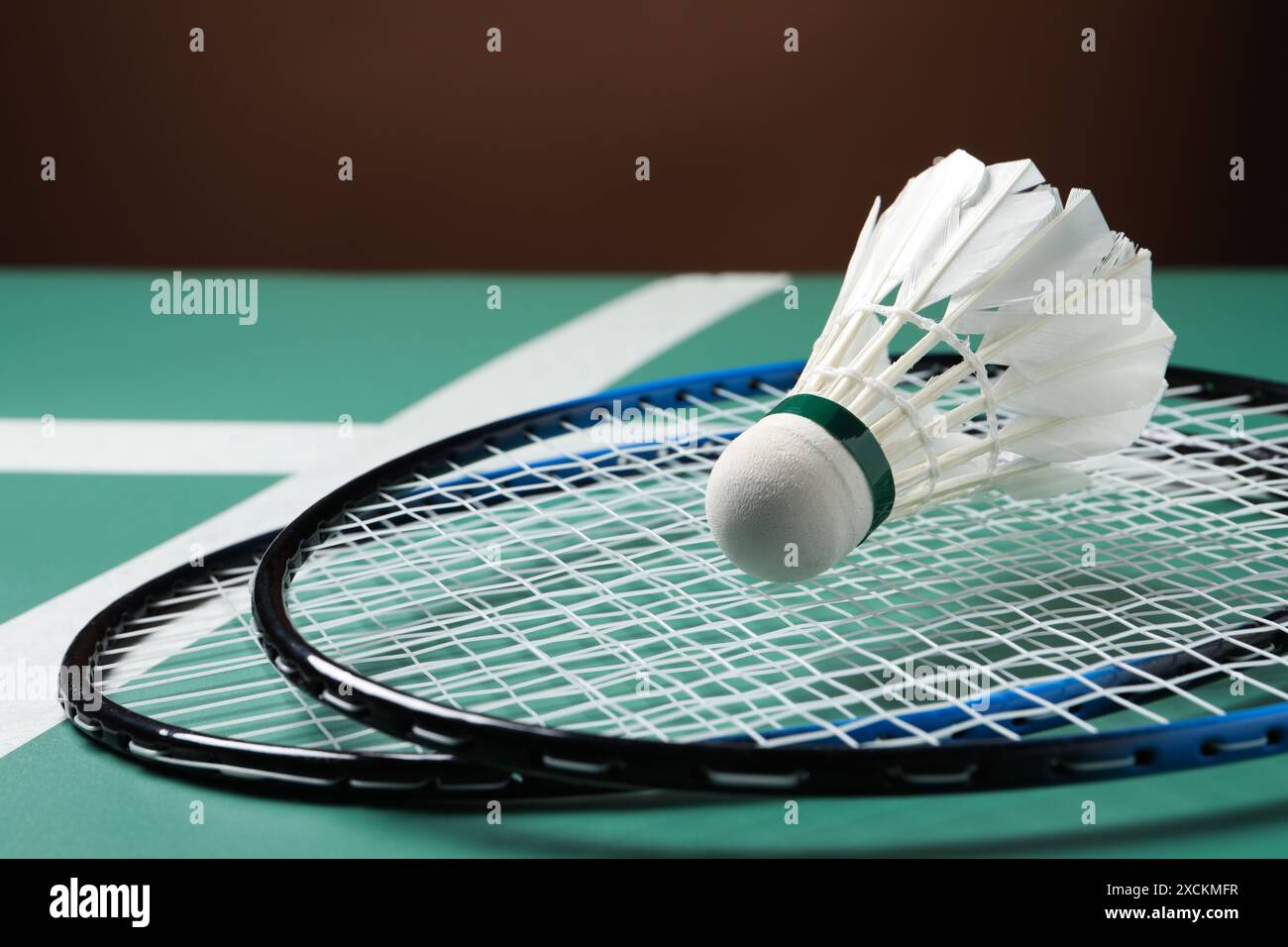 Feather badminton shuttlecock and rackets on court, closeup Stock Photo ...