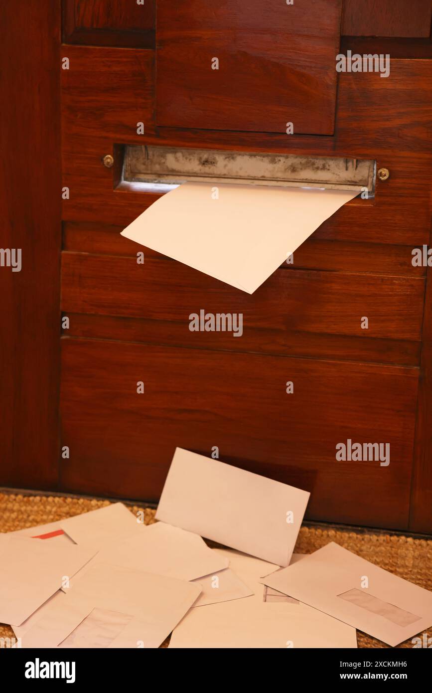 Wooden door with mail slot and many envelopes indoors Stock Photo - Alamy