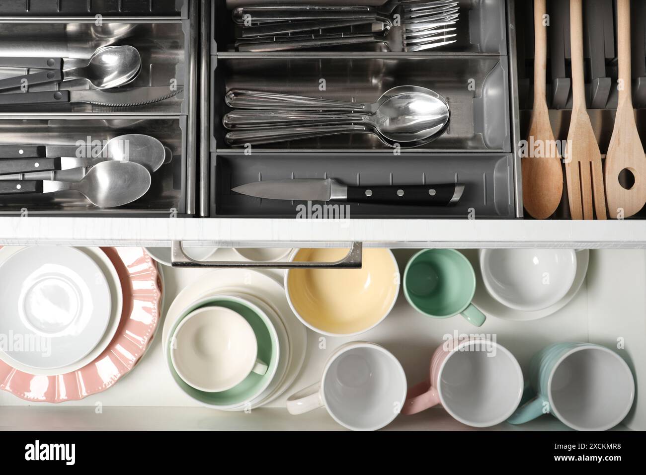 Ceramic dishware, utensils and cutlery in drawers, top view Stock Photo ...