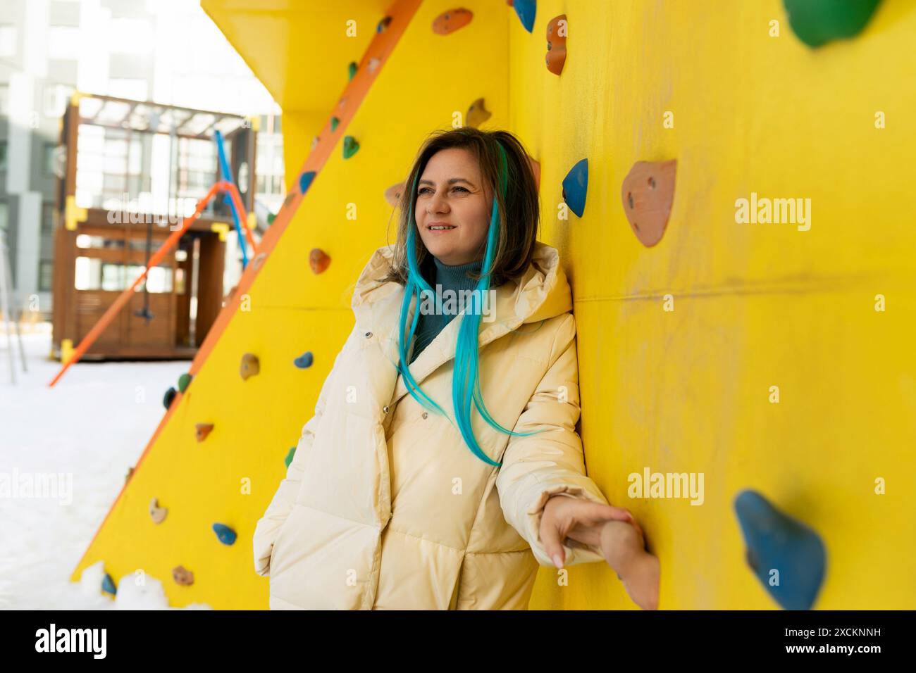 Woman Standing Next to Yellow Climbing Wall Stock Photo - Alamy