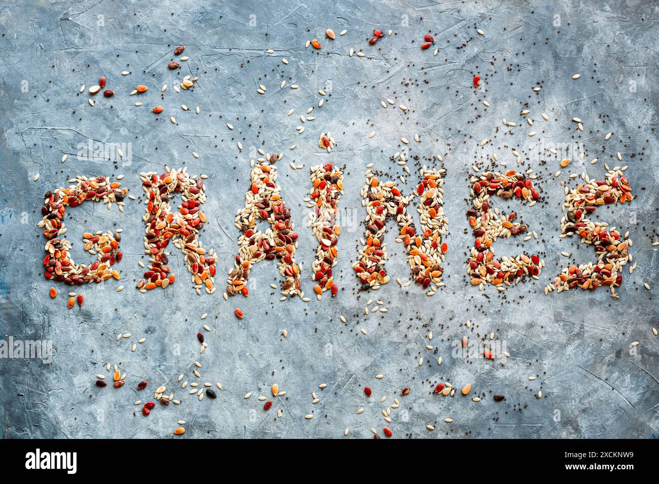 French word GRAINES (meaning SEEDS) is laid out on a grey background of ...