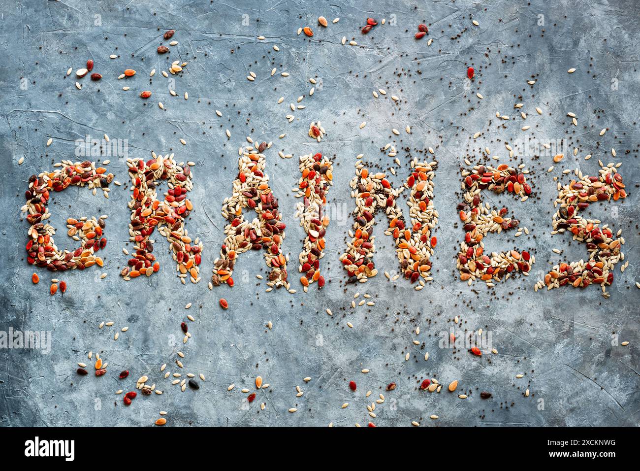 French word GRAINES (meaning SEEDS) is laid out on a grey background of ...