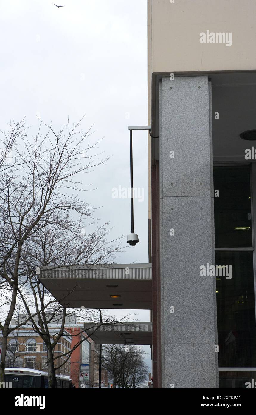 Surveillance camera on modern urban austere building exterior, with ...