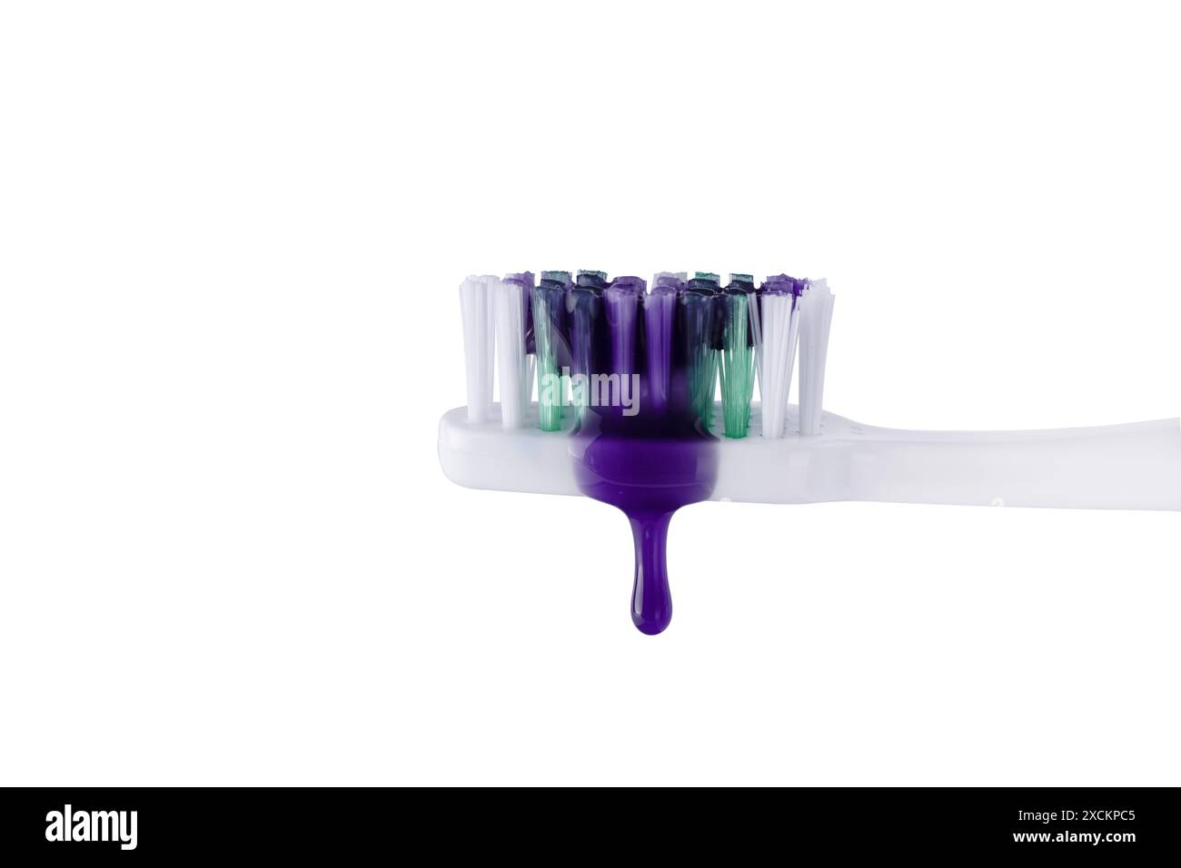 Swatch of whitening purple toothpaste on a toothbrush isolated on white ...