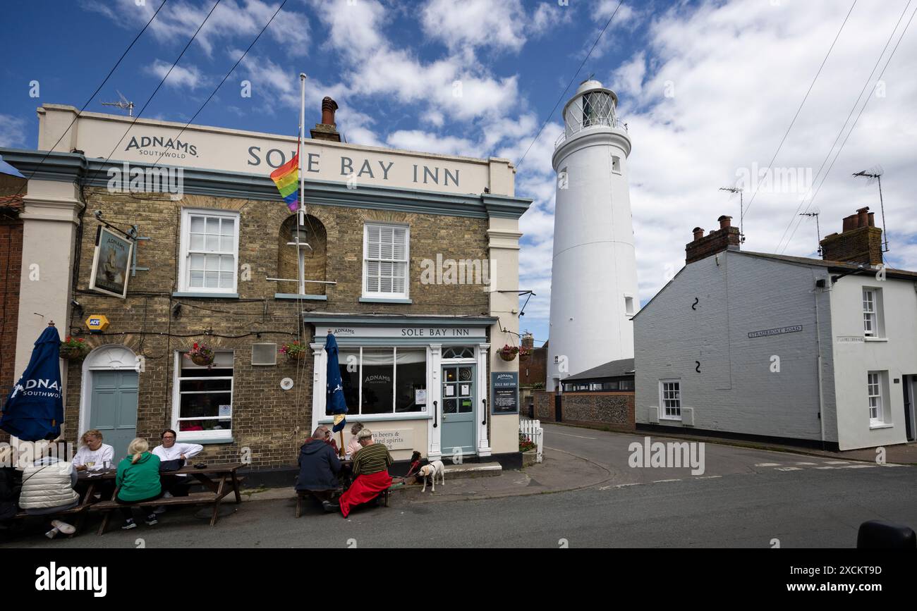 Sole bay Inn pub alongside Iconic white lighthouse inland behind row of ...