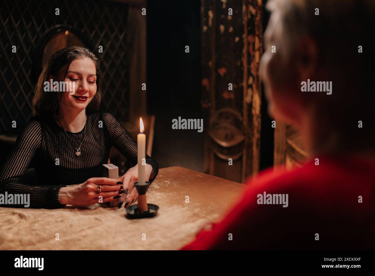 Portrait of fortune teller making tarot layout on table to mature adult ...