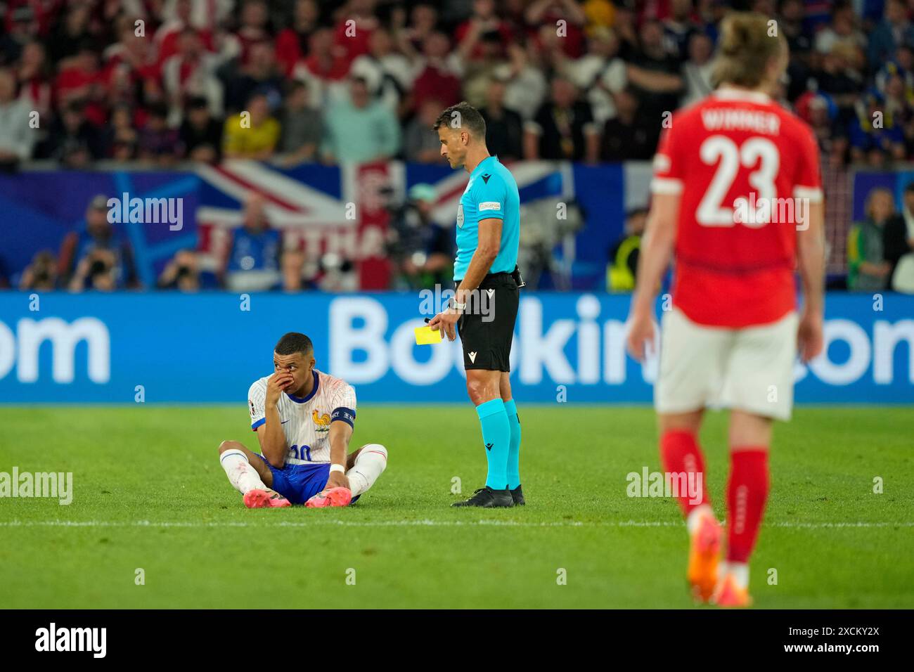 Kylian Mbappe of France sits on the pitch, hand over his bloody nose ...