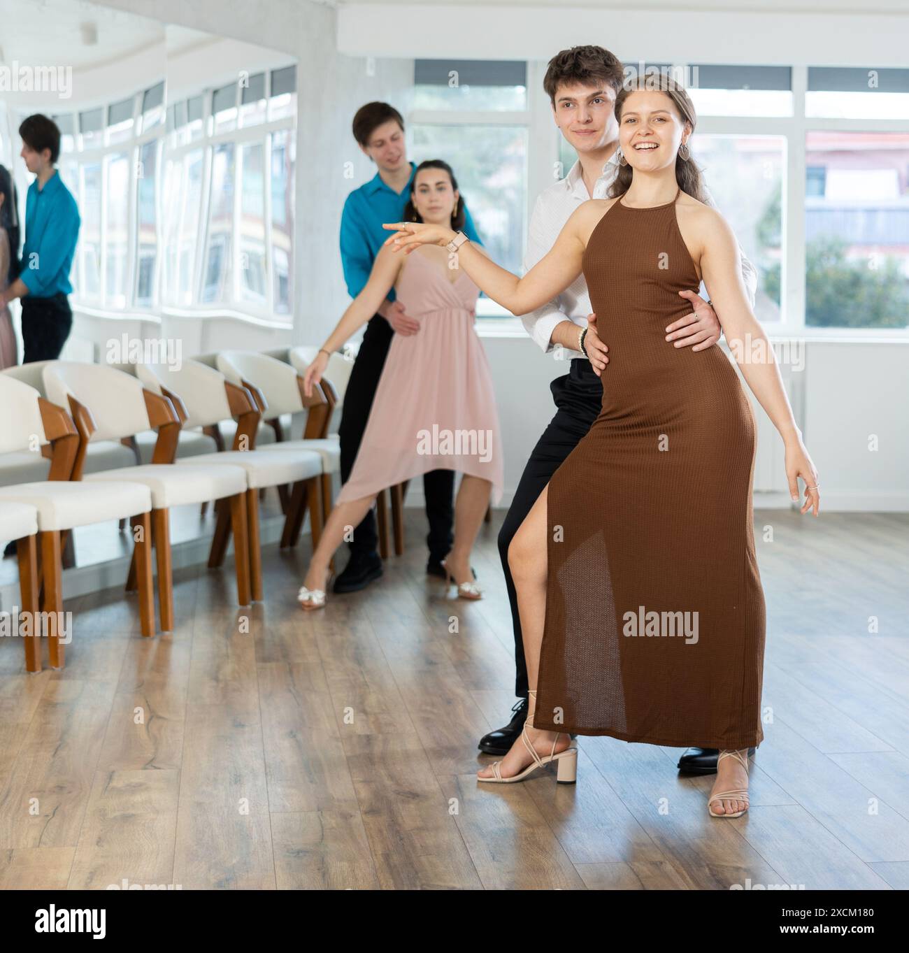 Dance studio where young couples in festive clothes learn to dance ...