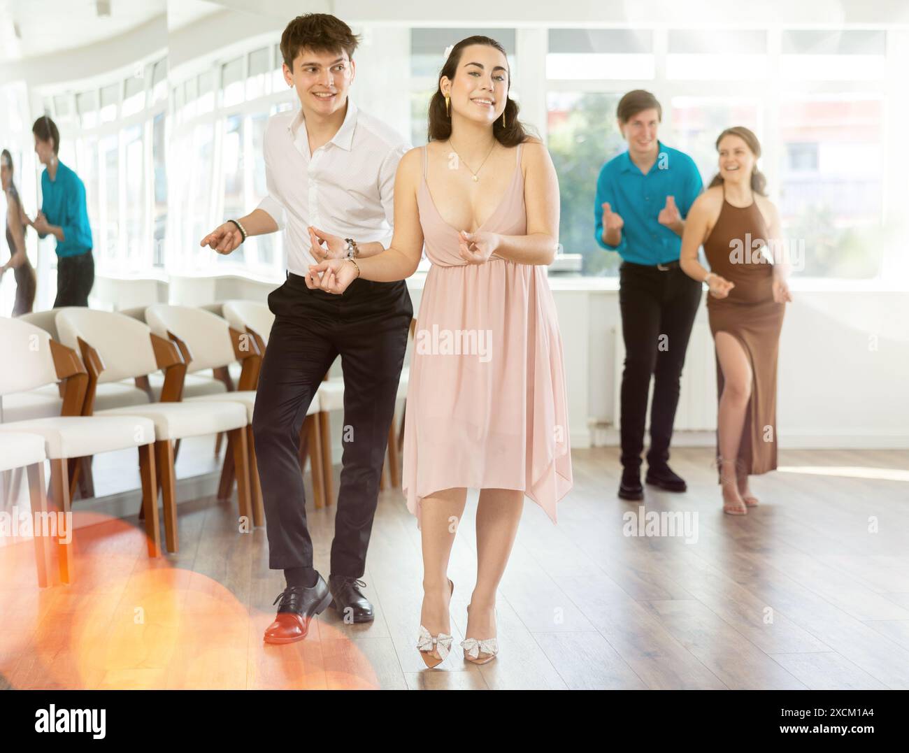 Couple in evening dresses enjoys pair dance boogie-woogie, interacting ...