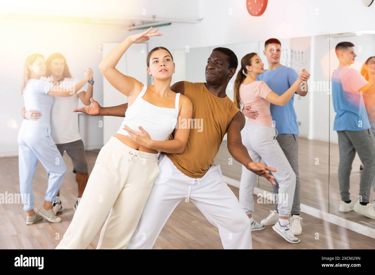 Group of excited young adult people dancing dynamic moves in pairs ...