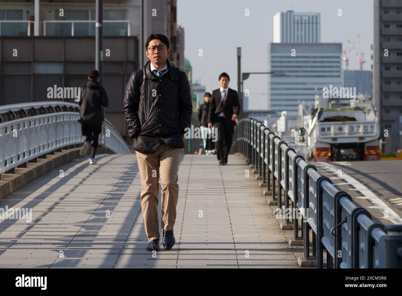 A Japanese salaryman crossing a road bridge in Odaiba, nTokyo, Japan ...