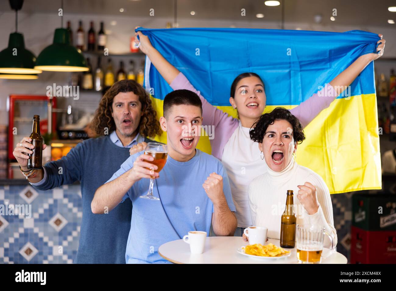 Happy friends of different ages drinking beer and celebrating the ...