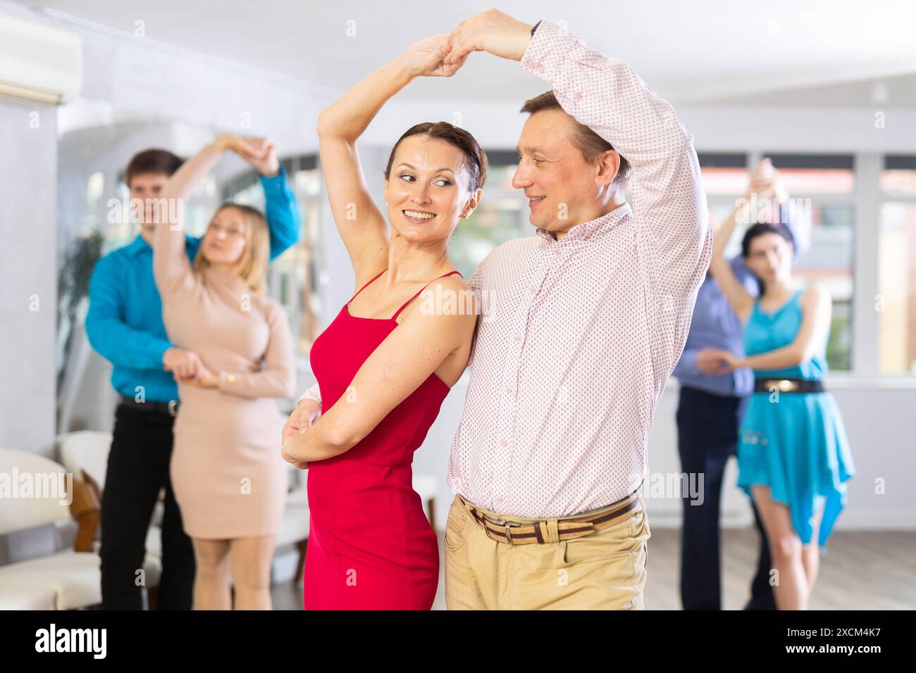 Group of different ages active people in festive clothes dancing dance ...
