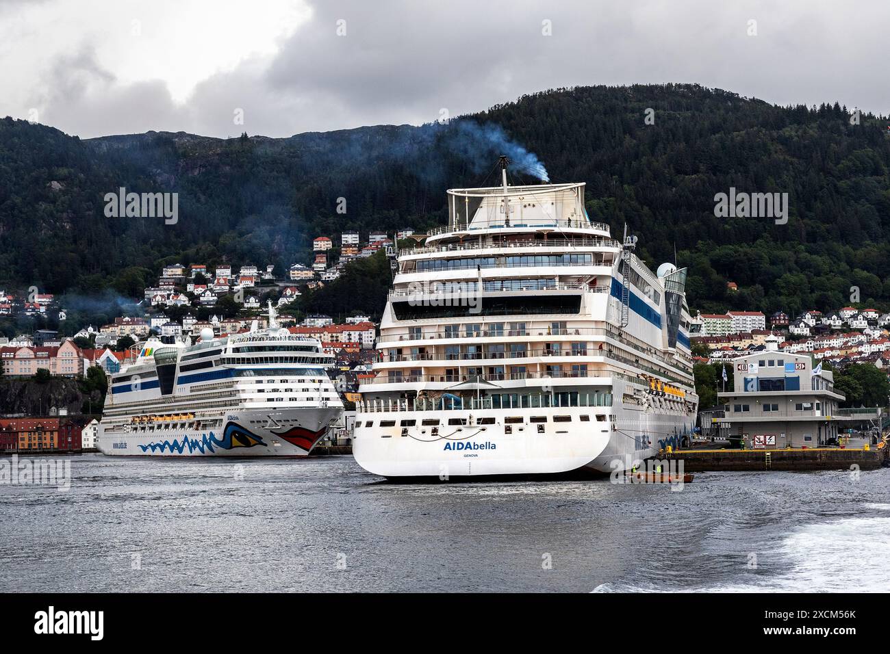 Cruise ship AIDAdiva preparing to depart, and stern of cruise ship AIDAbella still moored in ...