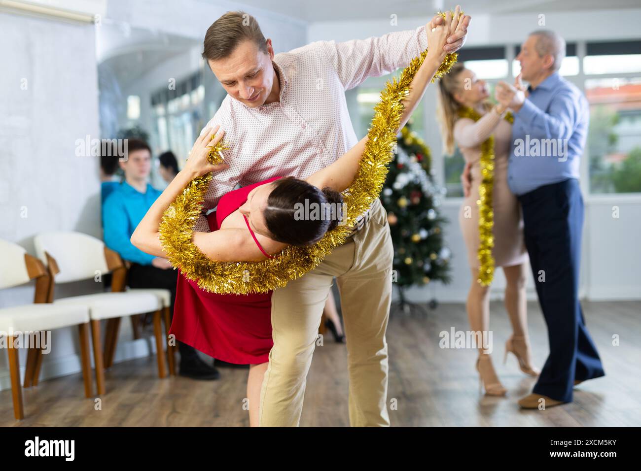 Couple performing dip move in dance at New Year celebration in office ...