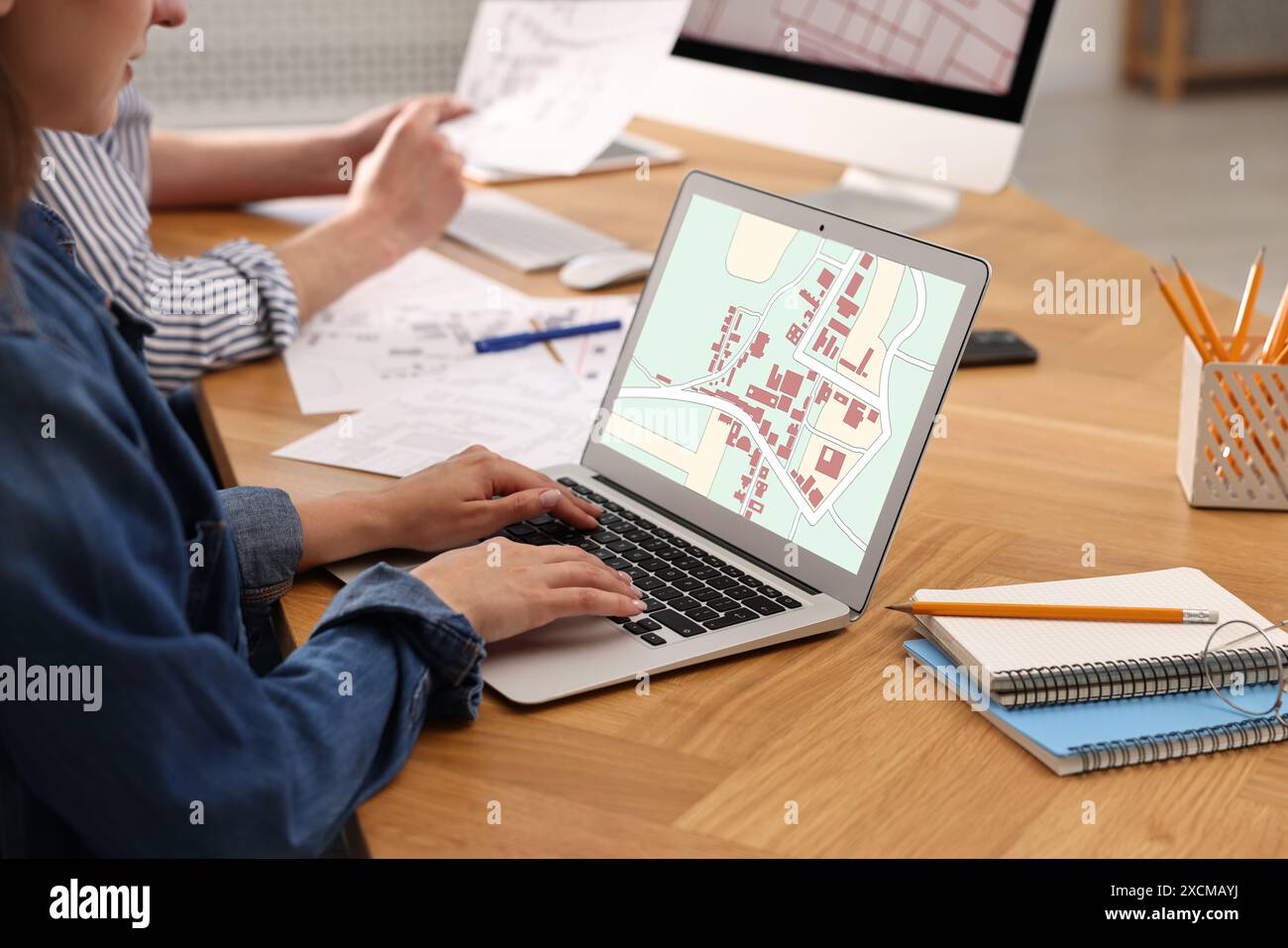 Cartographers working with cadastral maps at table in office, closeup ...