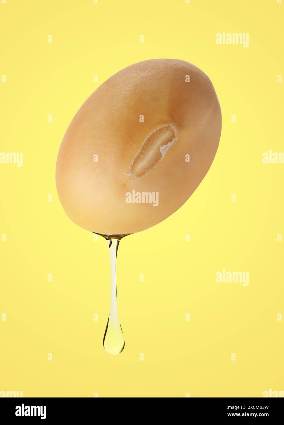 Cooking oil dripping from soybean on yellow background Stock Photo - Alamy