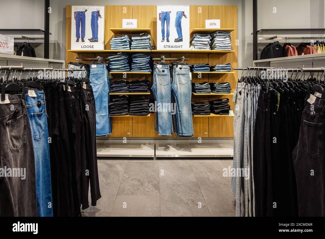 Men's jeans displayed on shelves and racks inside a modern fashion ...