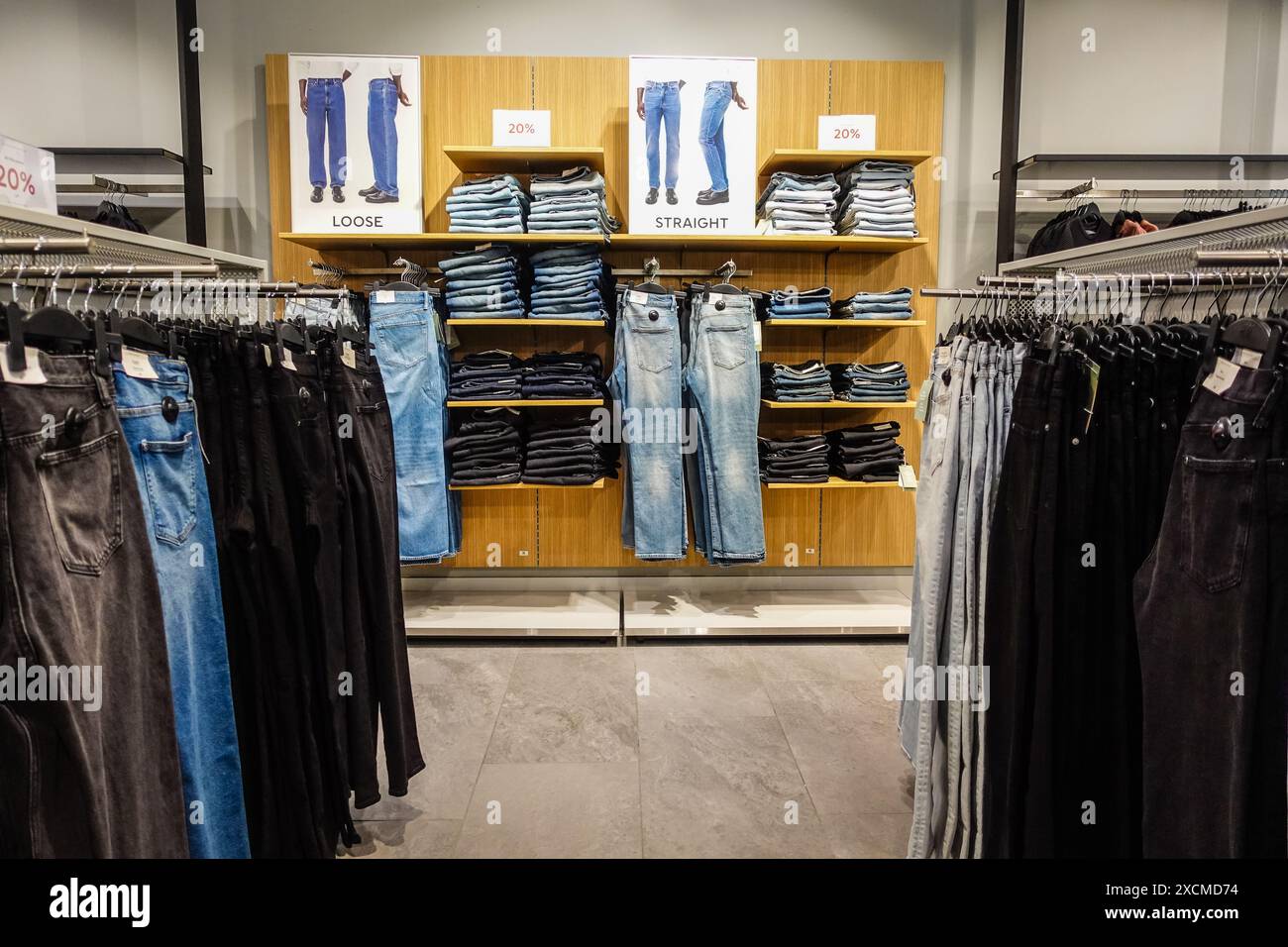 Men's jeans displayed on shelves and racks inside a modern fashion ...
