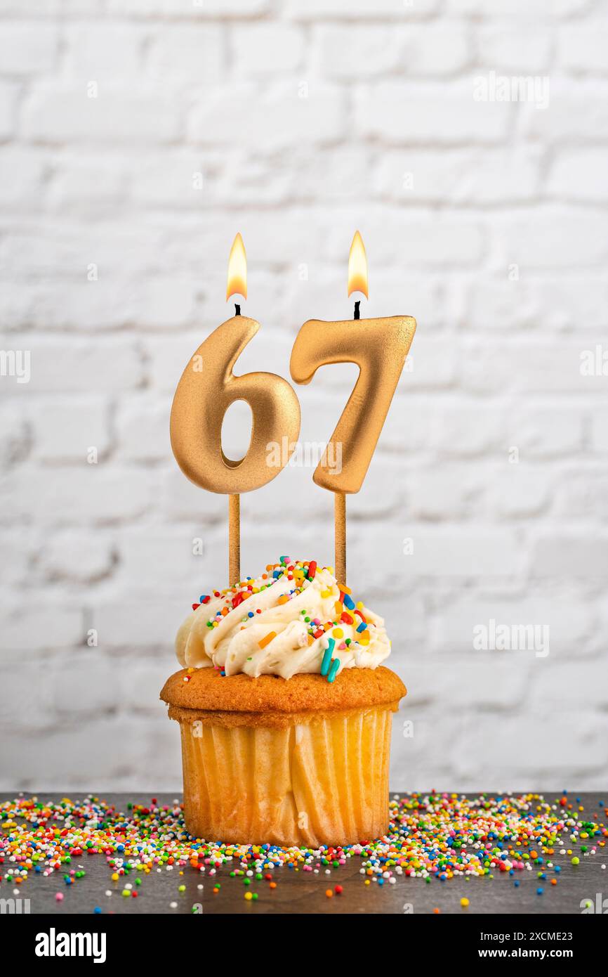 Golden birthday candle number 67 with cupcake - White block wall ...