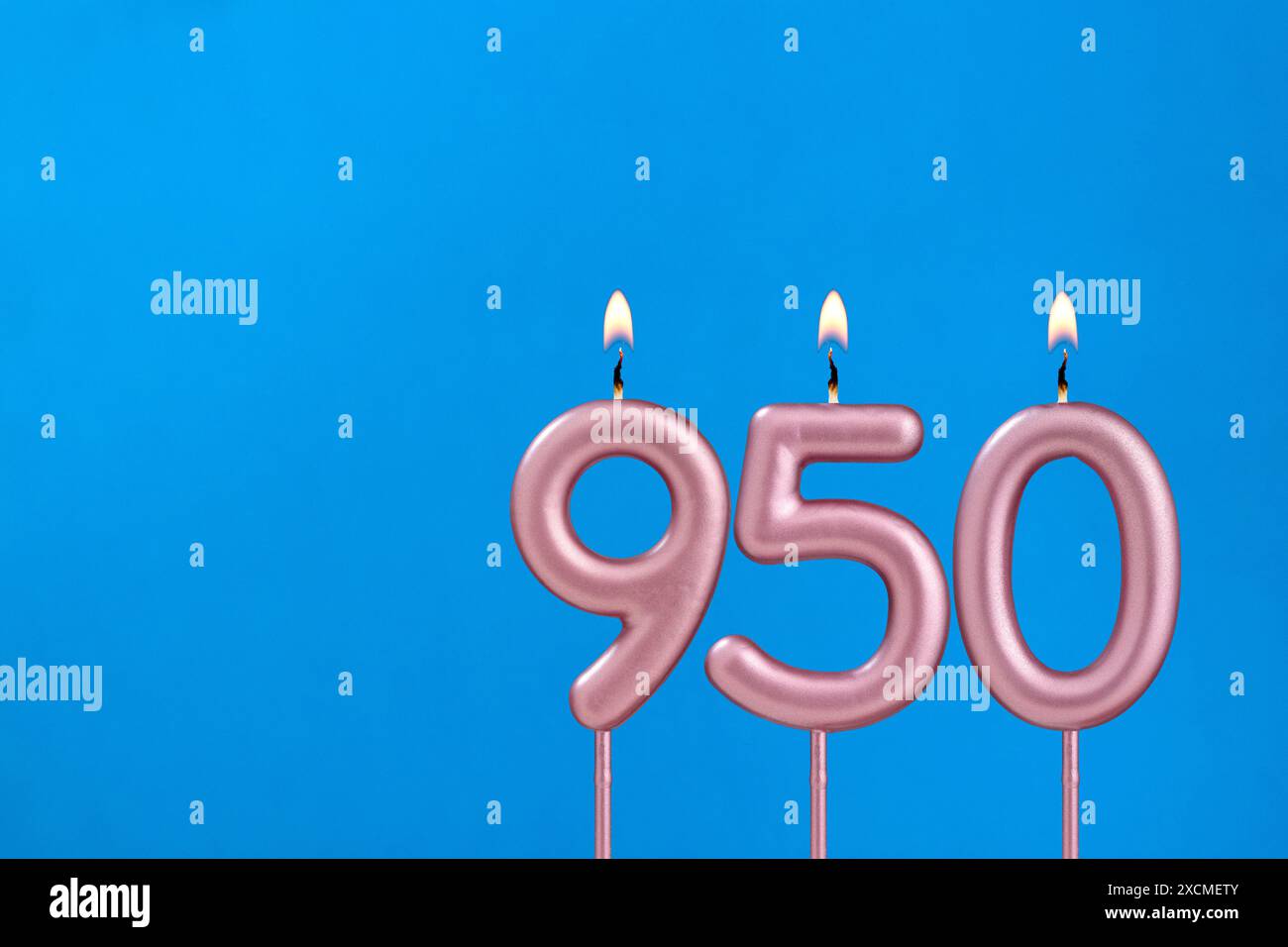 Number 950 - Burning anniversary candle on blue foamy background Stock ...