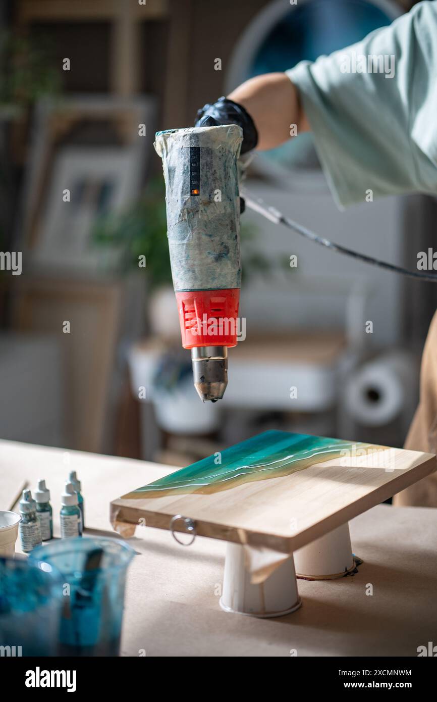 Artistic woman working on epoxy resin painting. Stages of creating ...