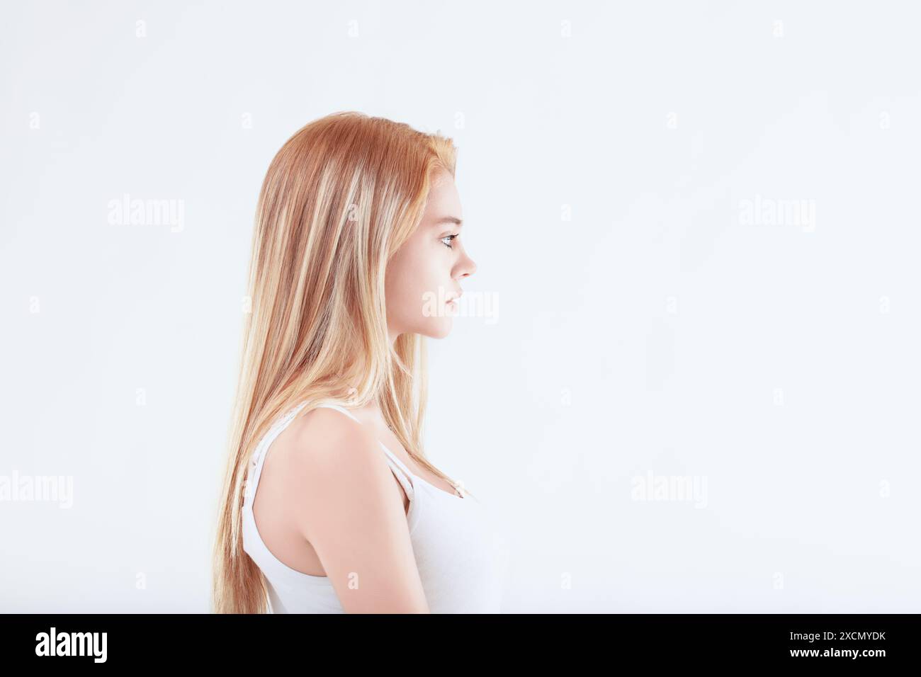Portrait of a young woman with long blonde hair standing against a ...