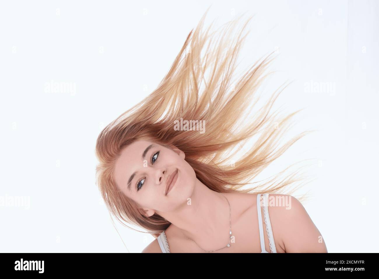 Portrait of a young woman with long blond hair moving her head on a ...