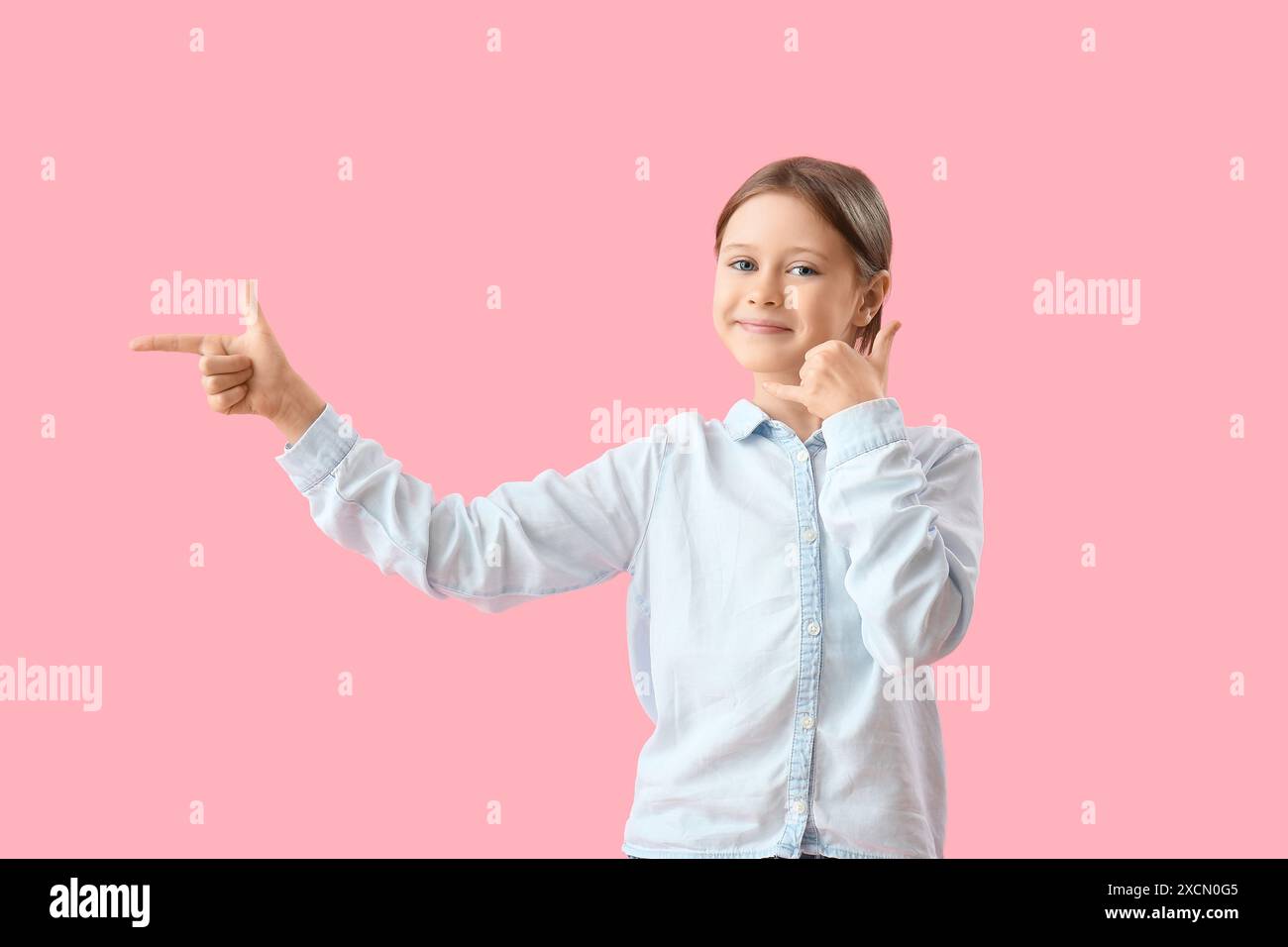 Little girl showing "call me" gesture on pink background Stock Photo ...