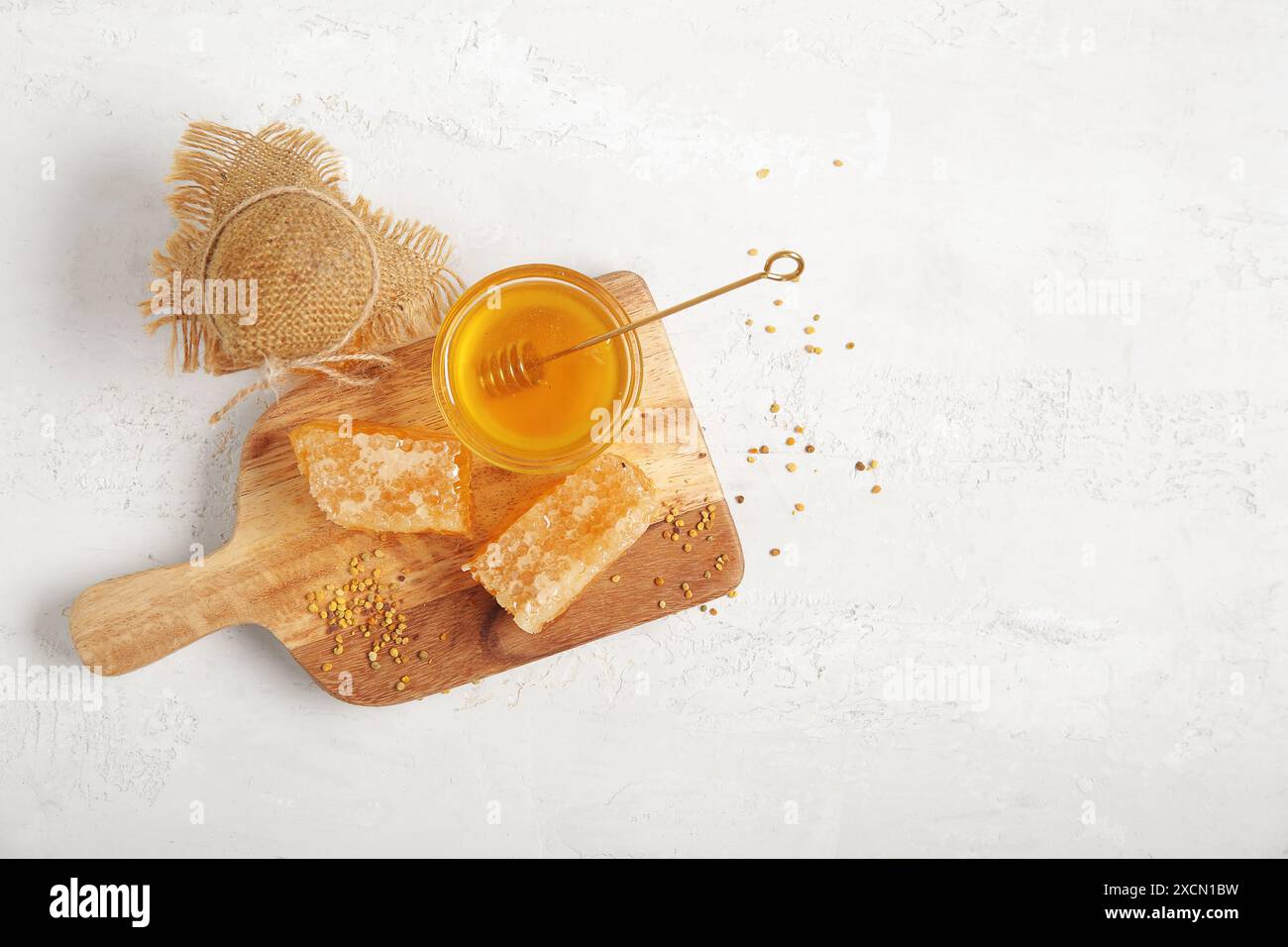 Wooden board with bowl of sweet honey, combs and bee pollen on light ...